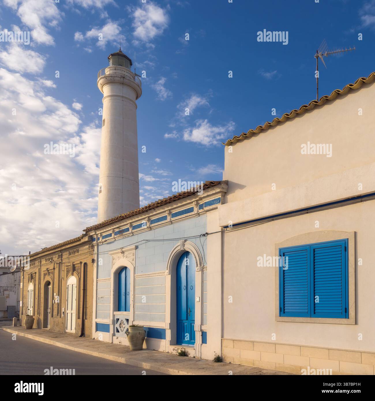 Golden hour lights up Punta Secca’s lighthouse and colorful buildings ...