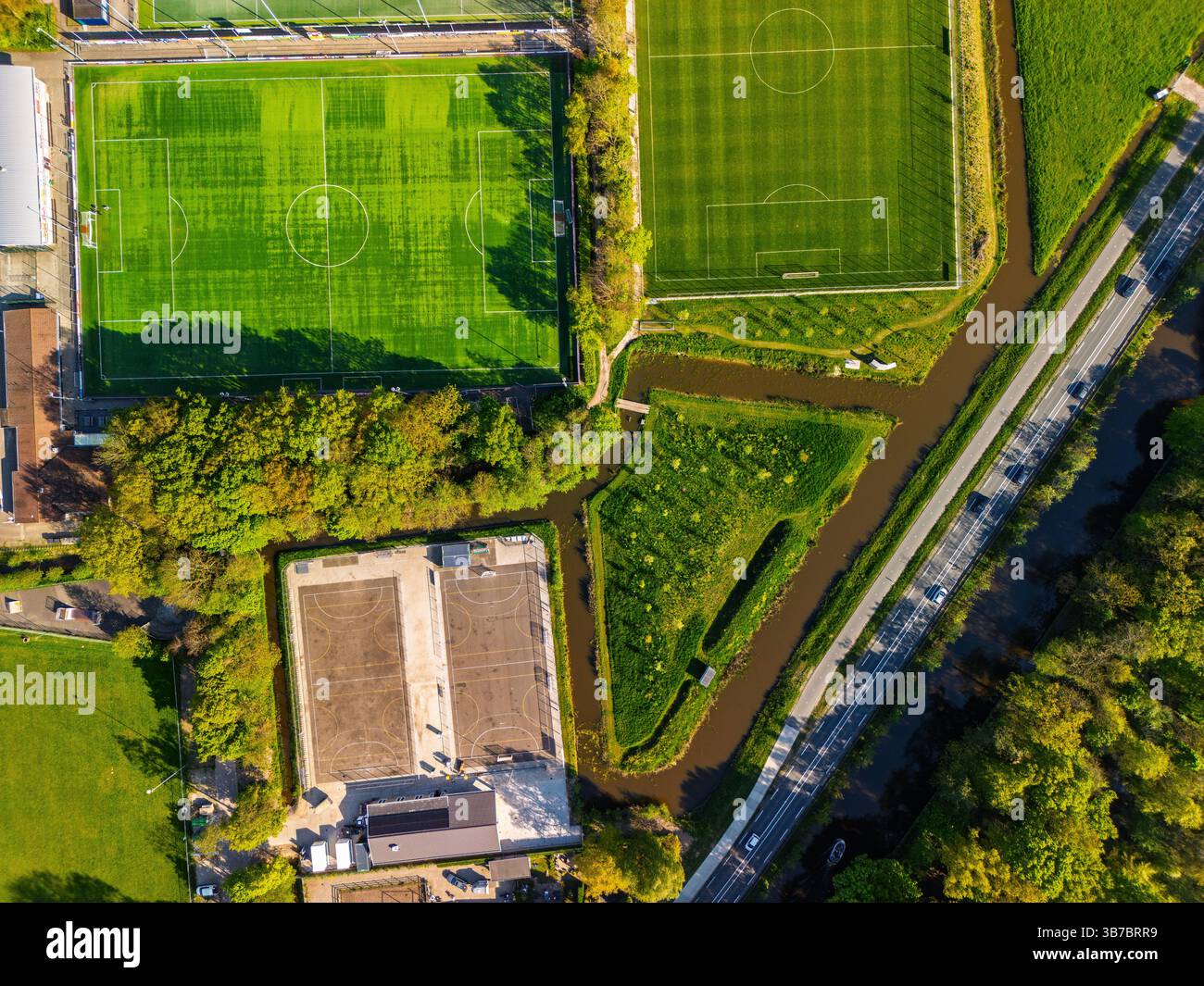 Aerial view from above of a green sports field with white markings ...