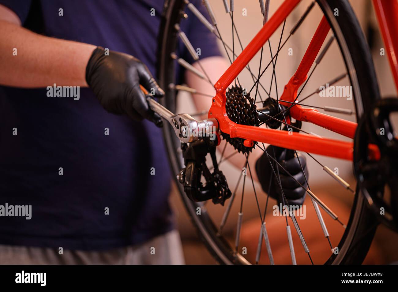 Close-up of gloved hands using a ratchet wrench to secure the rear ...