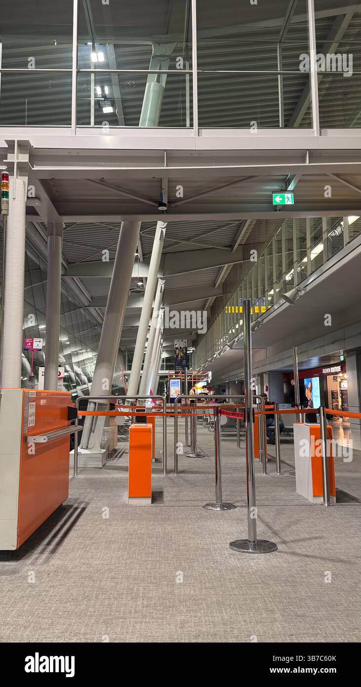 Modern airport departure area with orange check-in counters and glass ...