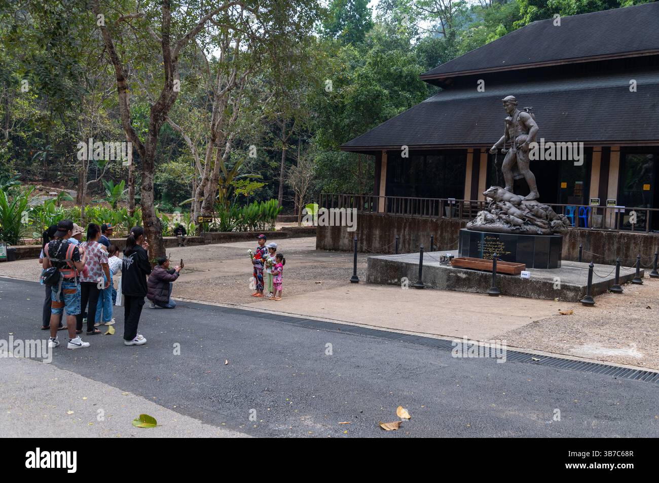 A group of tourists taking photos of a bronze statue of Saman Gunan, a ...