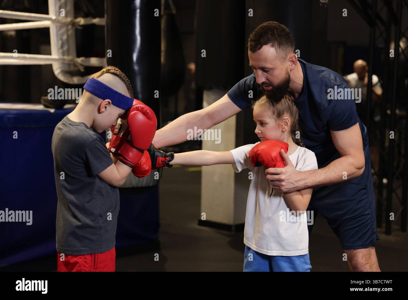 Boxing coach training children in sport center Stock Photo - Alamy