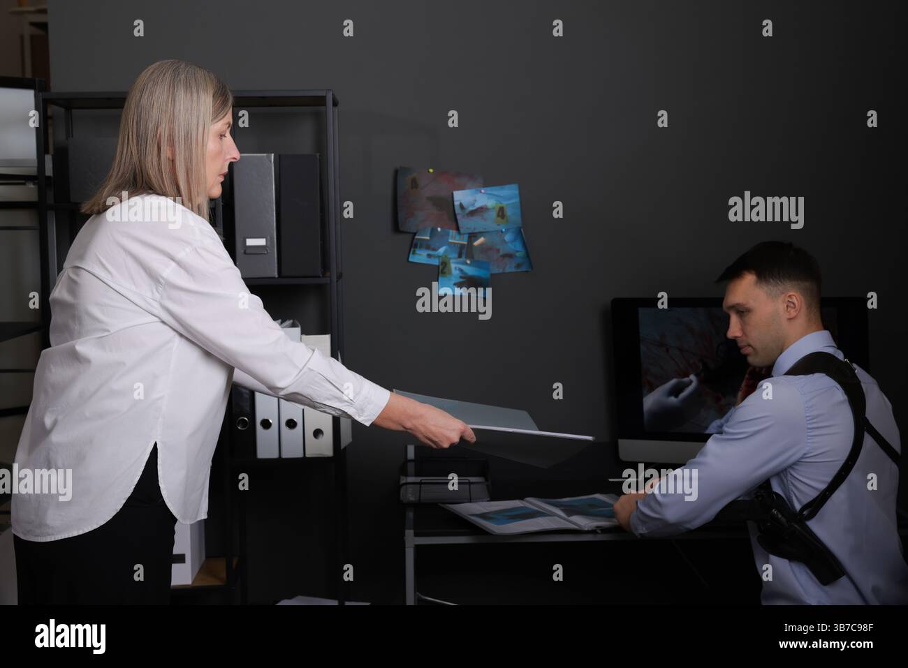 Forensic experts working with crime scene photos in office Stock Photo ...