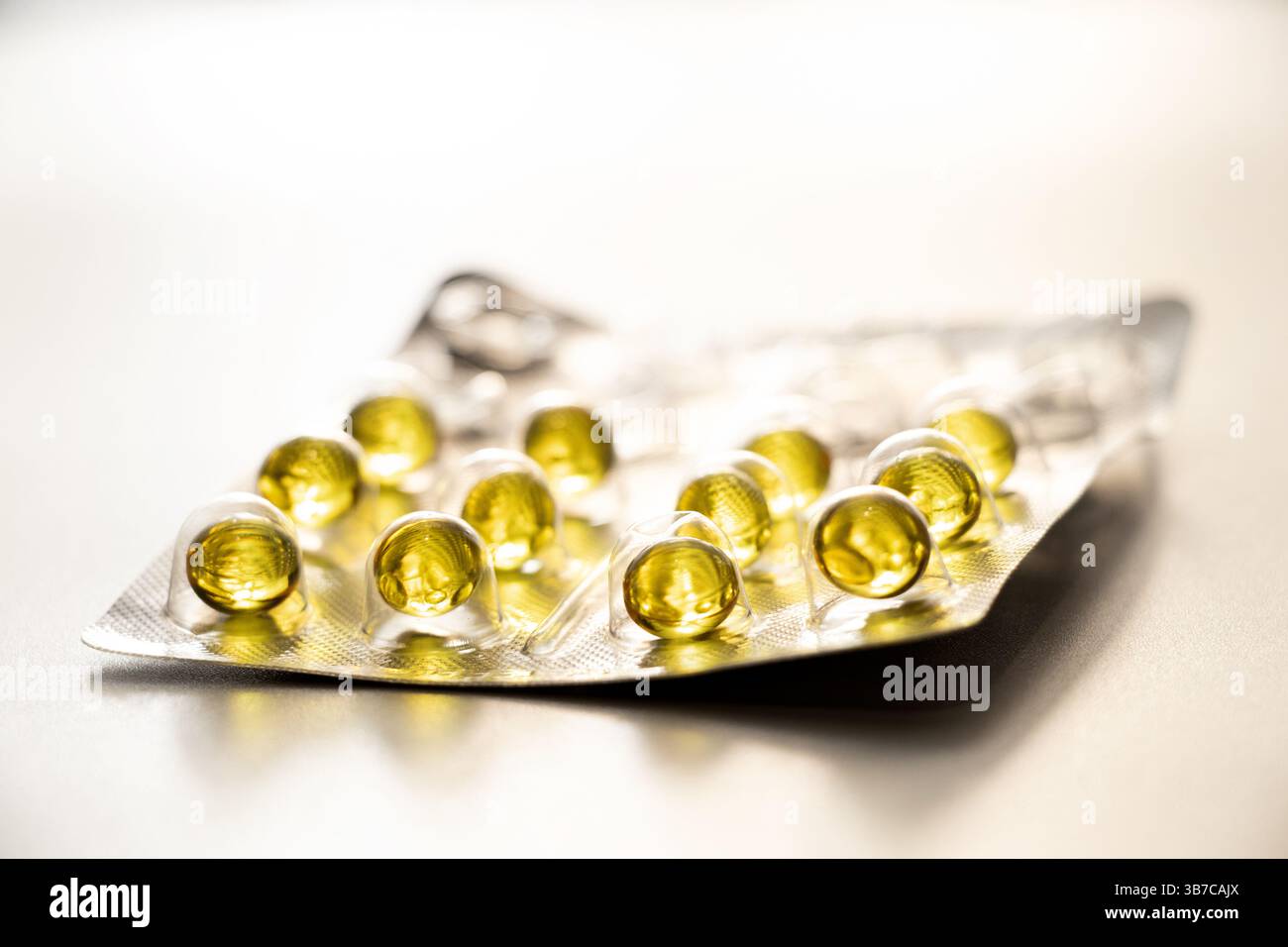 Yellow capsules in a blister on a light background, medicines and ...