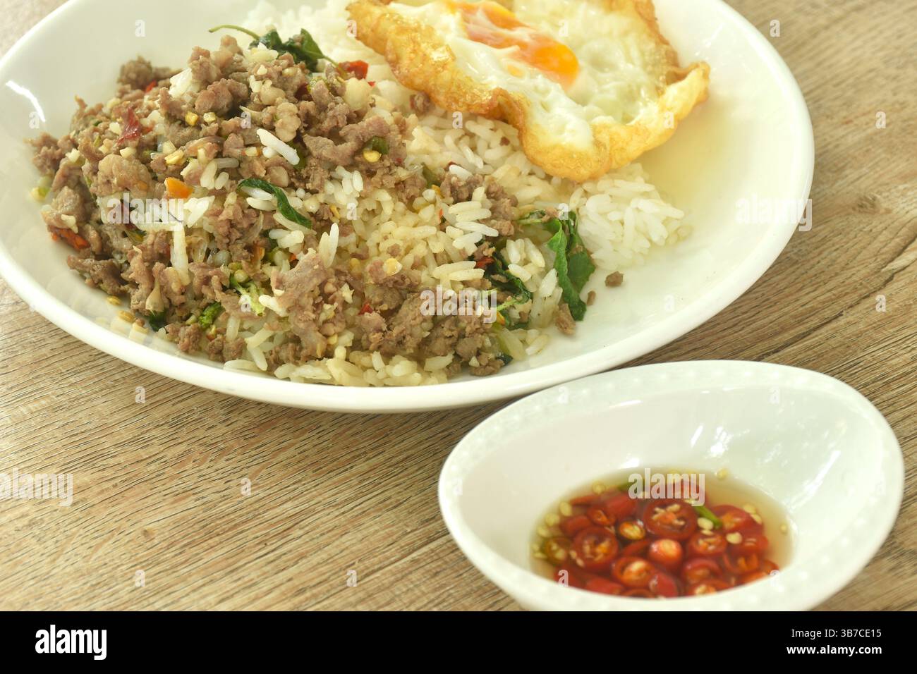 spicy stir fried chop beef meat with basil leaf and chili on rice ...