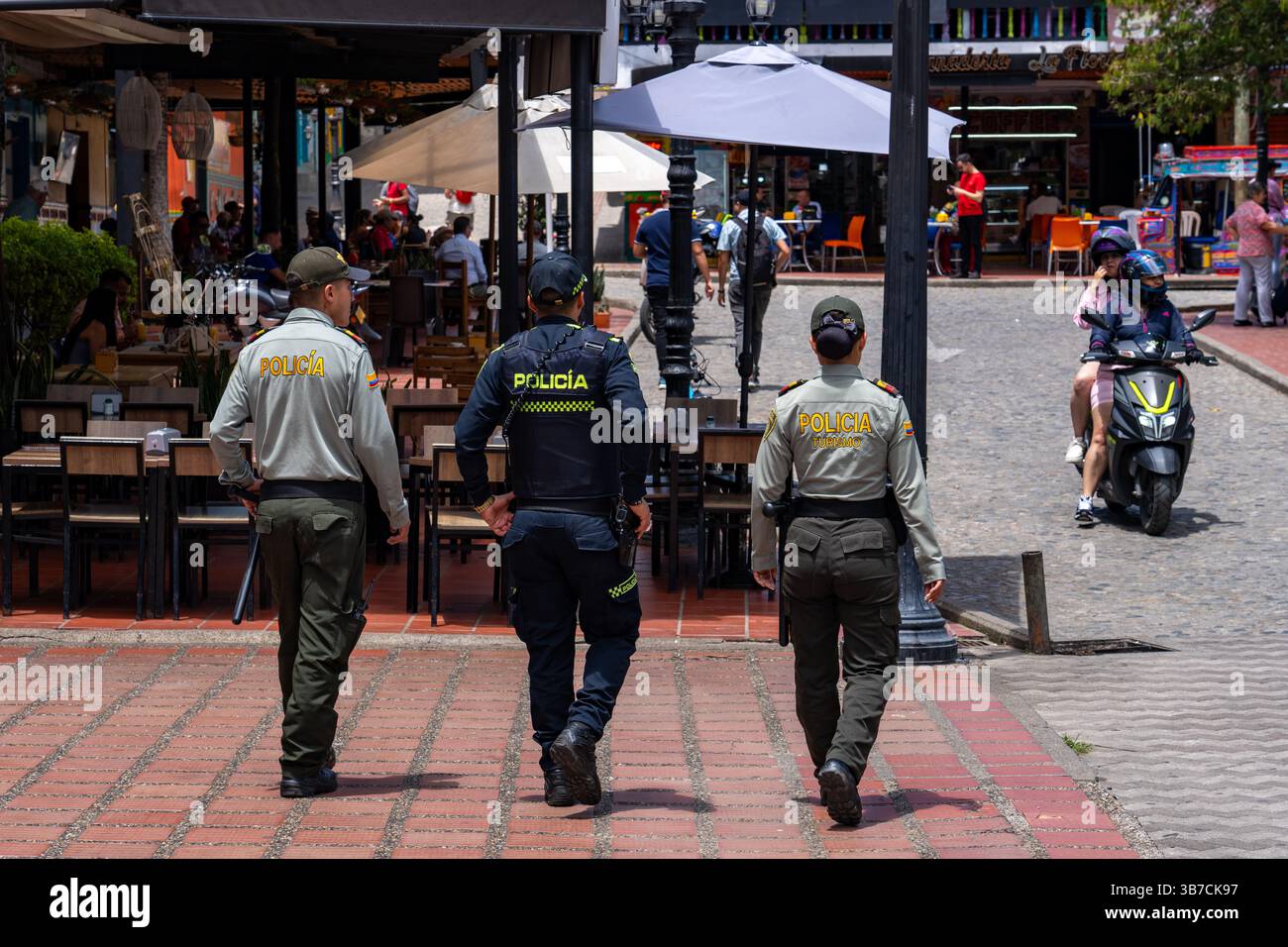 Three Colombian police officers patrol the street in the tourist town ...