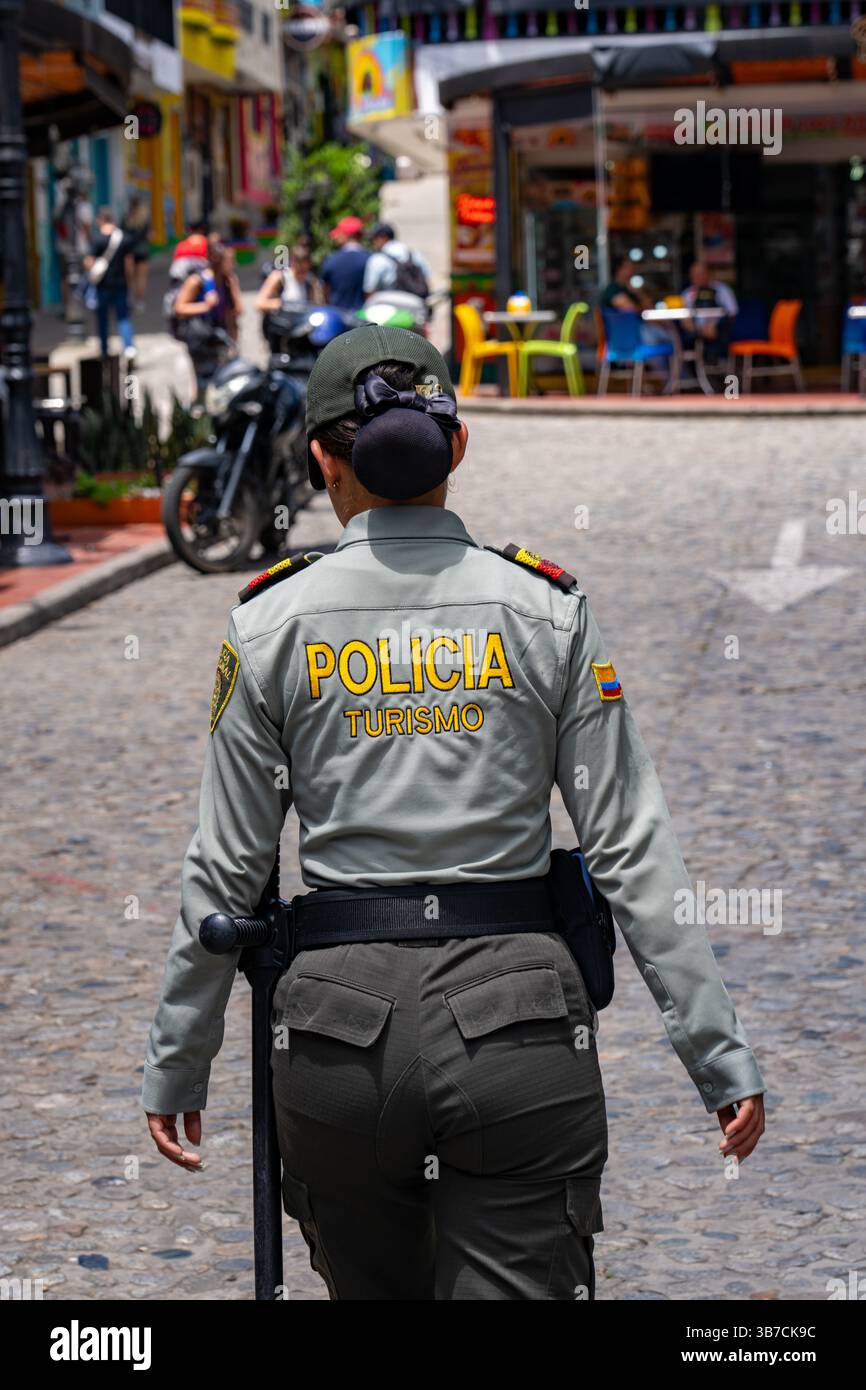 A female Colombian tourist police officer patrols the street in the ...
