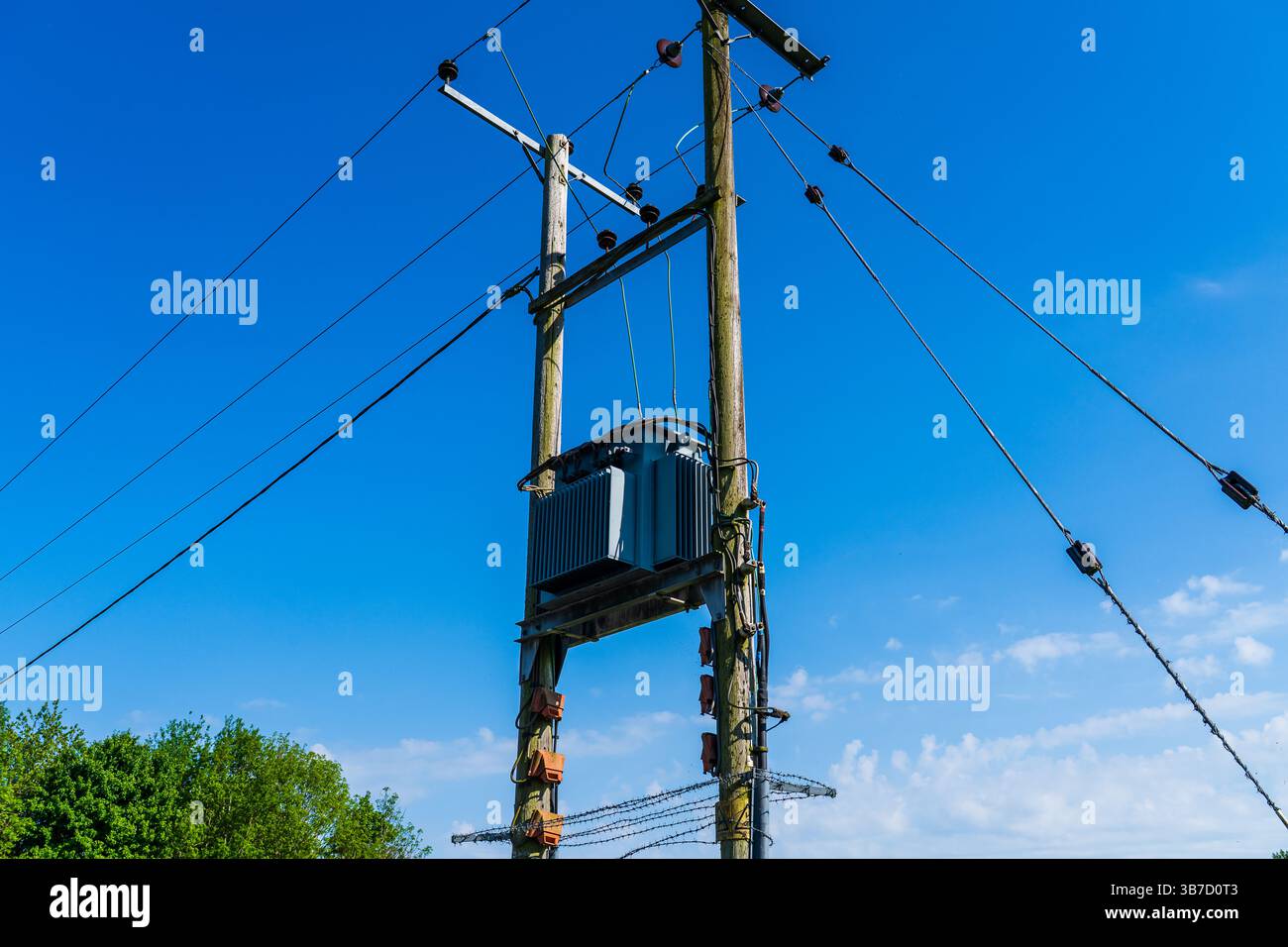Long view of a UK electricity pole transformer and overhead power ...