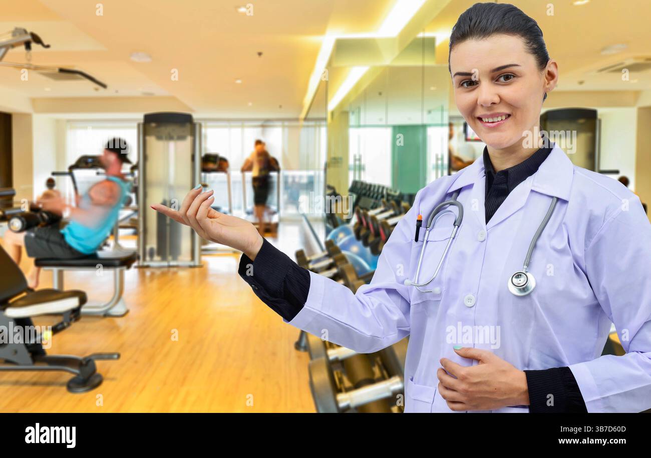 Beautiful young doctor with stethoscope on fitness room background ...