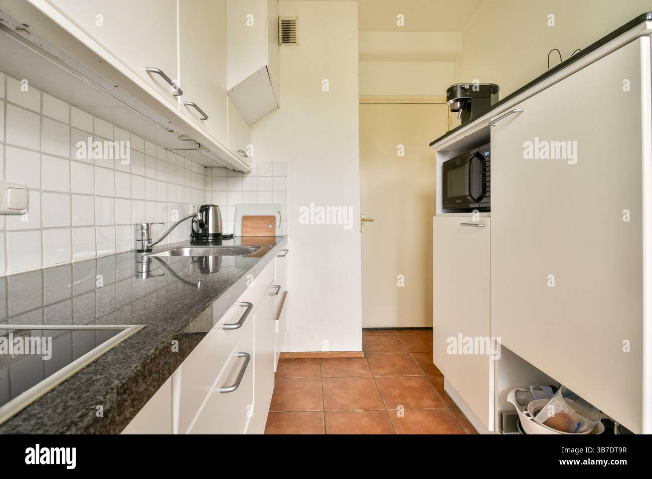 A sleek, modern kitchen featuring minimalistic cabinetry, granite ...