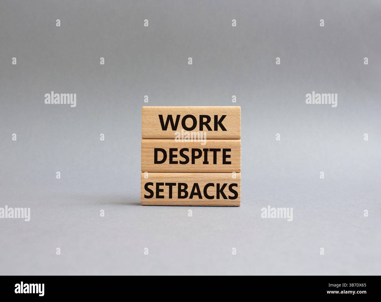 Work despite setbacks symbol. Wooden blocks with words Work despite ...
