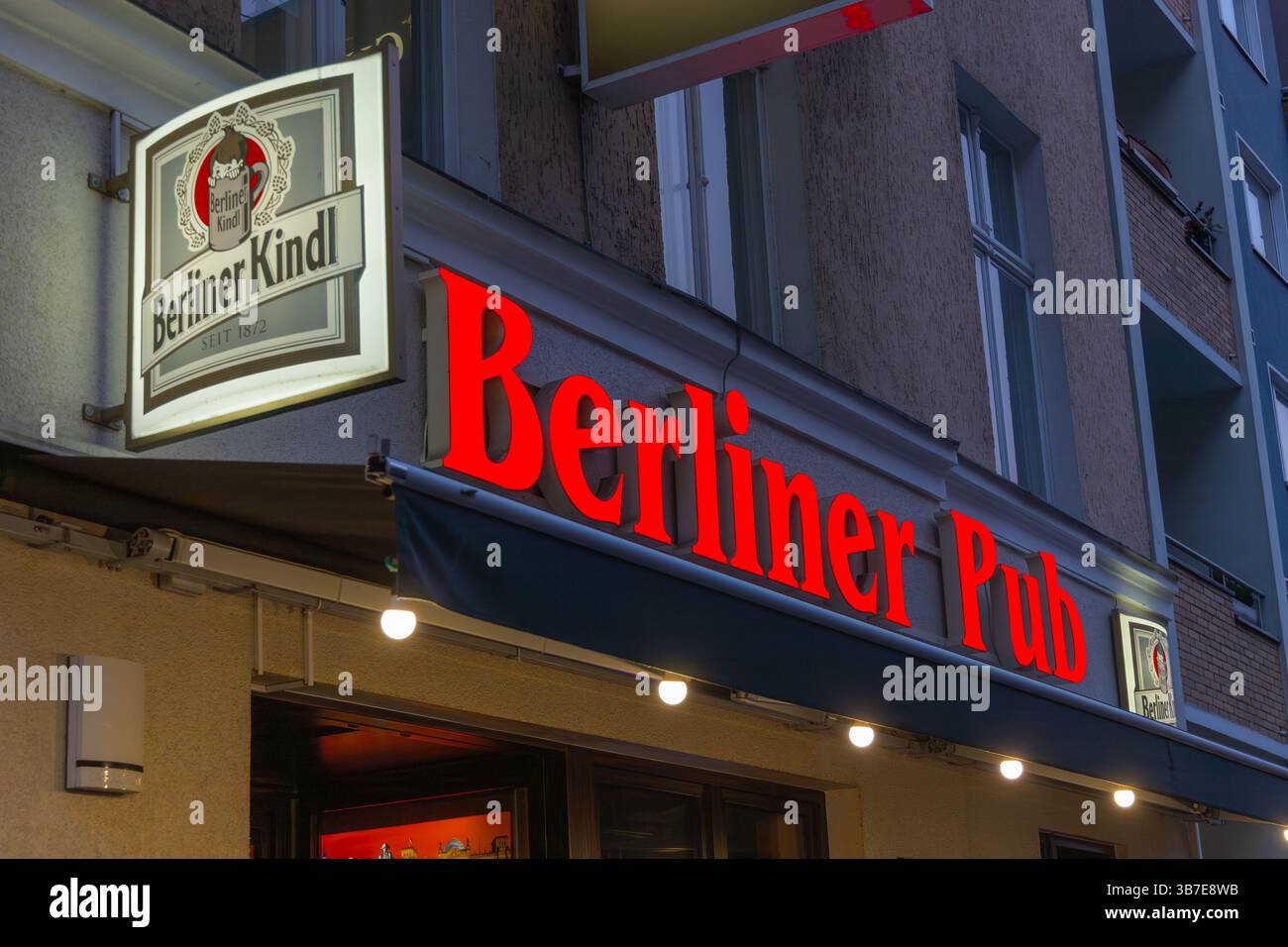 Illuminated Berliner Pub sign with Berliner Kindl logo at dusk, on a ...