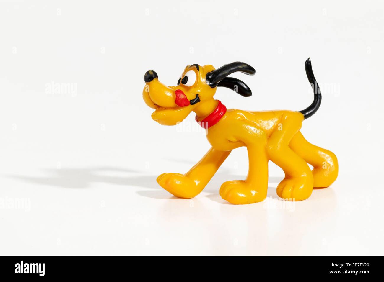 Yellow Pluto figurine walking on a white background Stock Photo - Alamy
