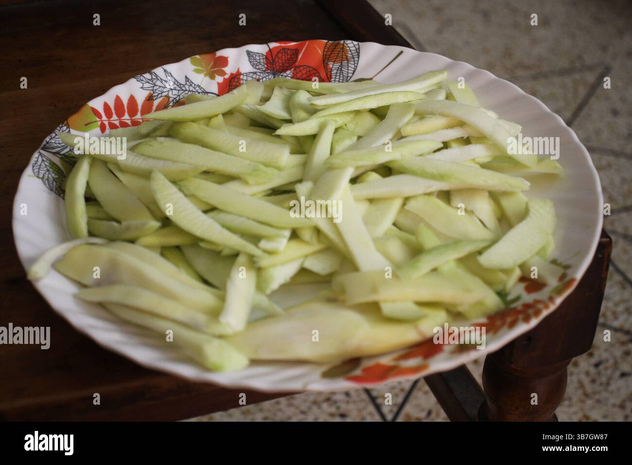 A plate is full of green sliced mango to make mango pickle Stock Photo ...