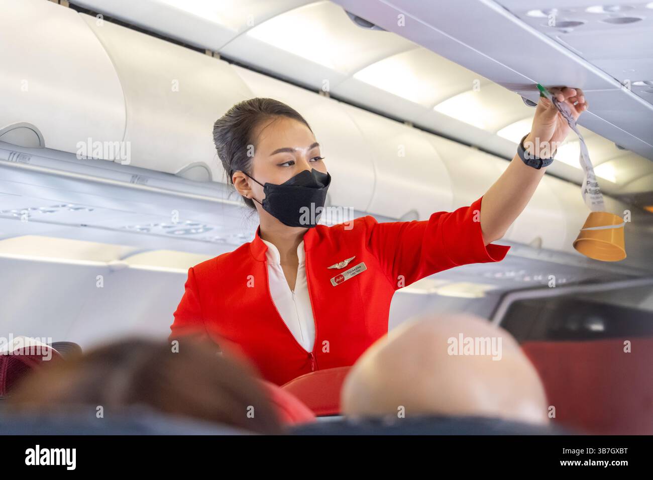 BANGKOK, THAILAND, APR 24 2025, A flight attendant on board an airplane ...