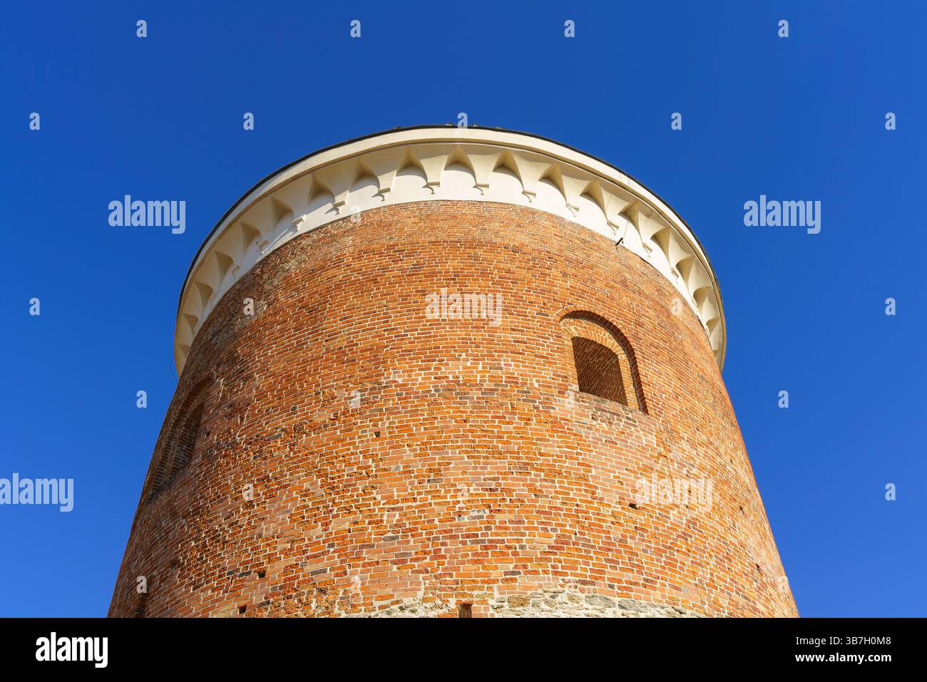 Romanesque brick tower on blue sky background located on courtyard of ...