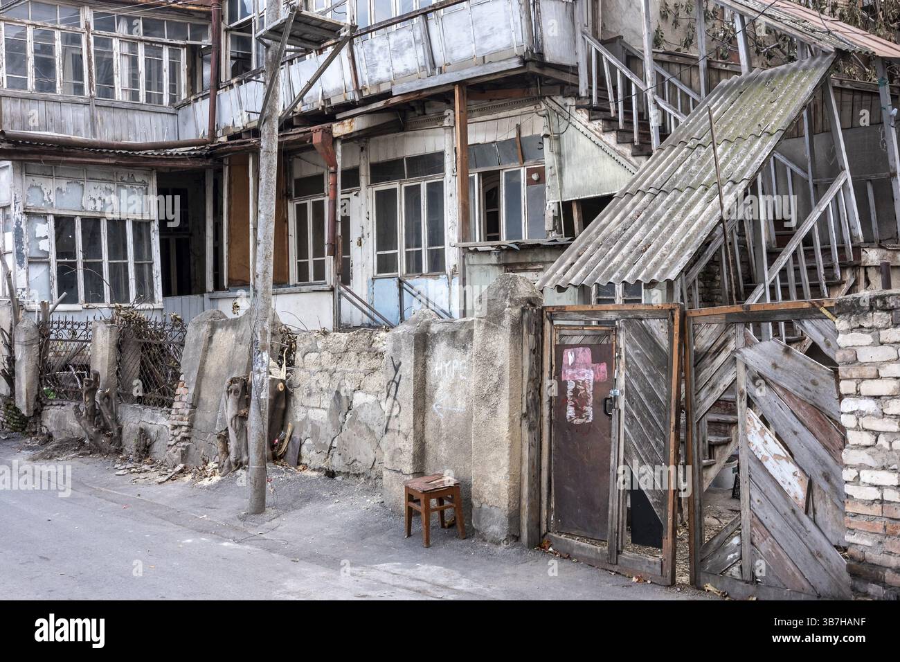 Worn building with stairs and abandoned chair in Tbilisi Stock Photo ...