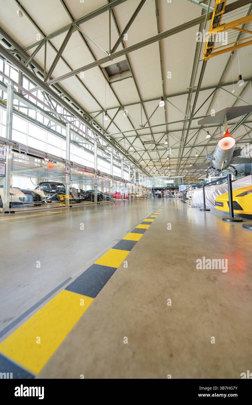 Hall with vehicles on display and yellow barrier line on the floor ...