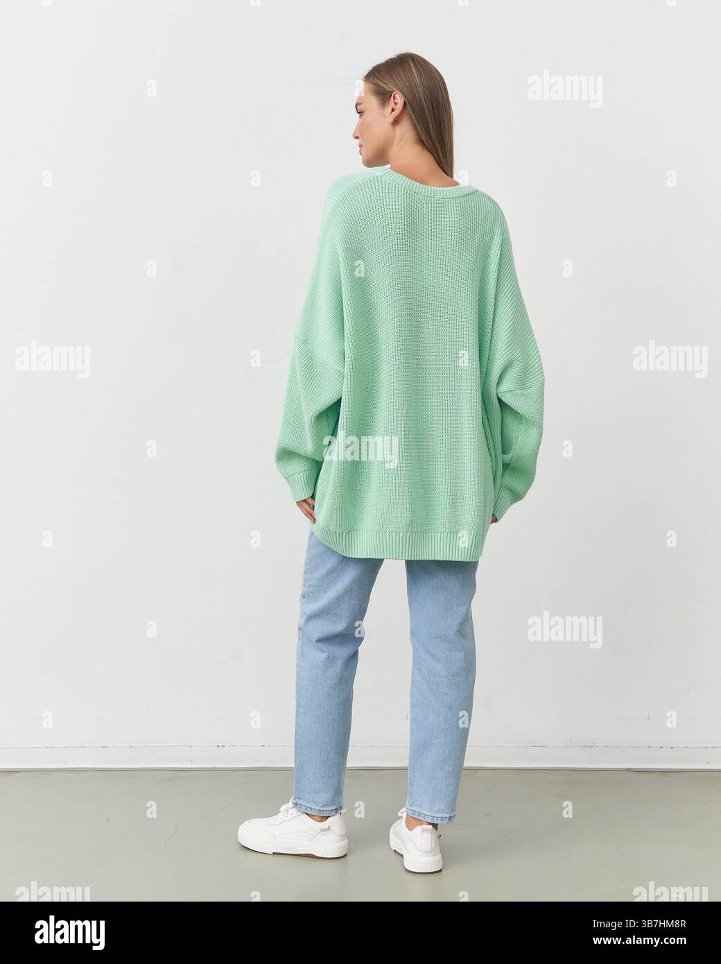 Stylish female model showcases casual fashion in a modern studio ...