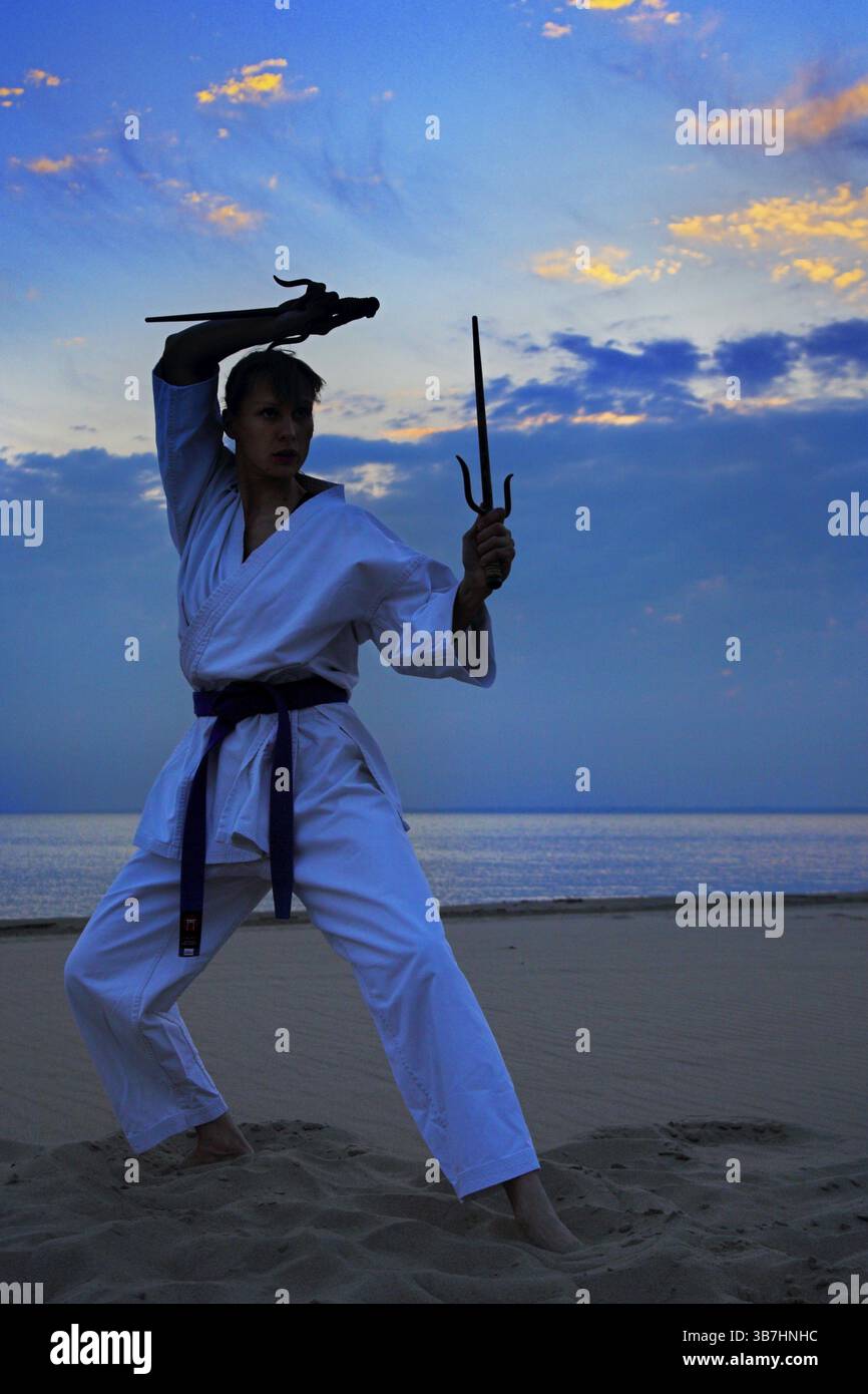 Young woman training karate on sunset beach Stock Photo - Alamy