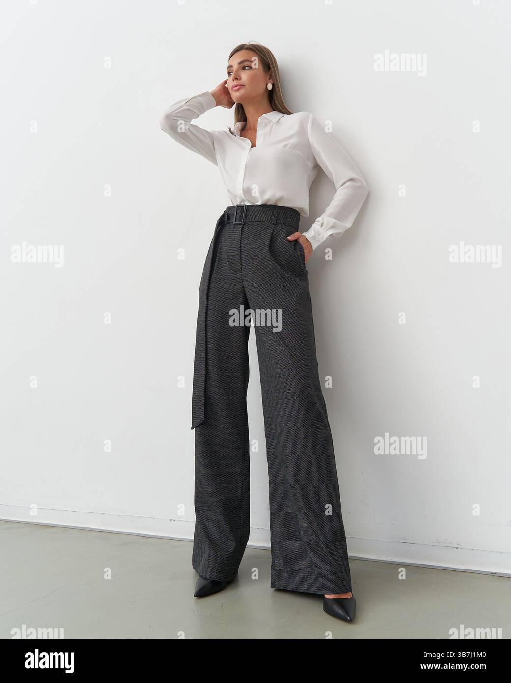 Elegant woman models chic fashion in a modern studio setting during a ...