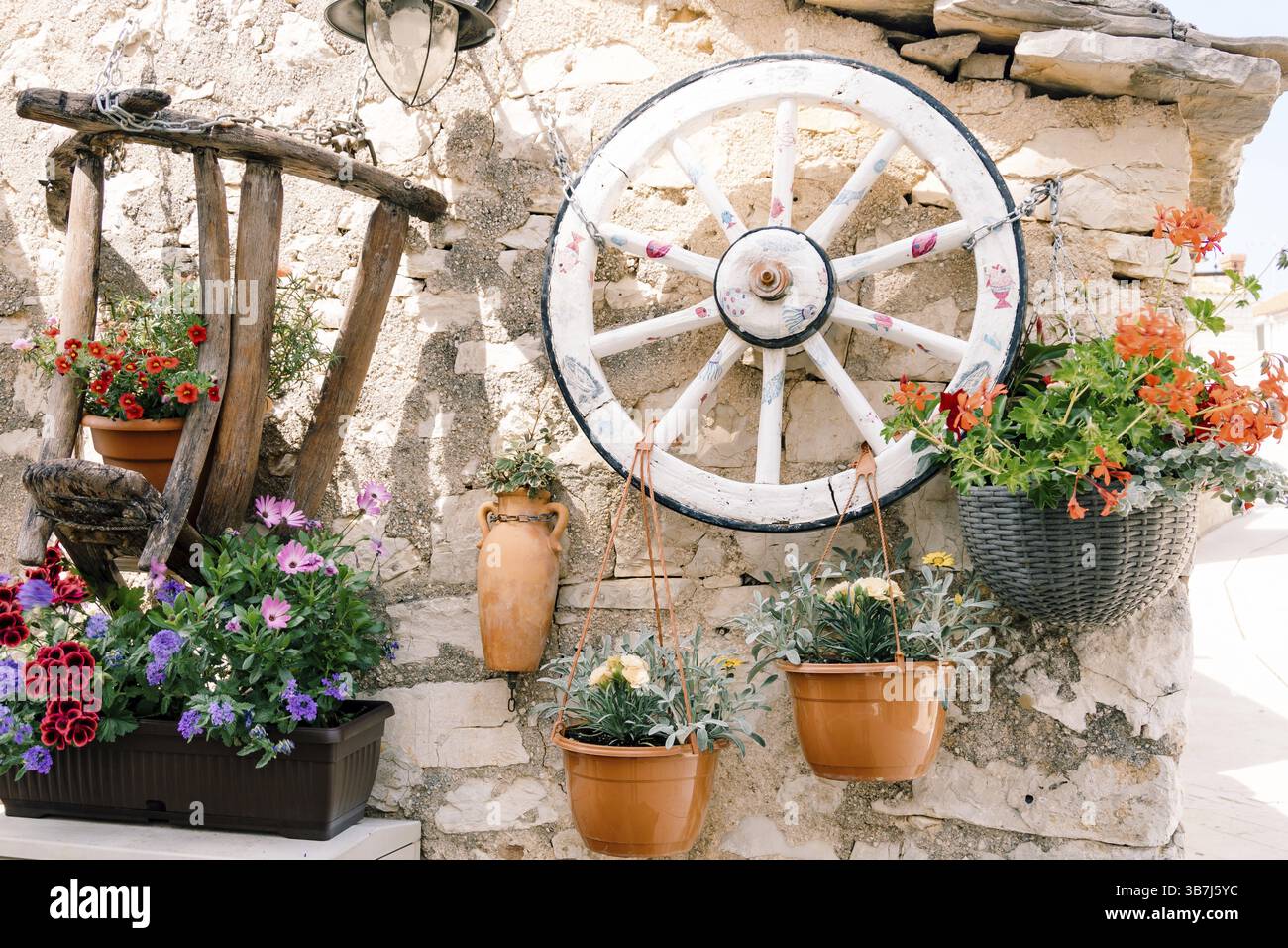 Wooden wheel from a cart in a garden interior. Country style photo zone ...