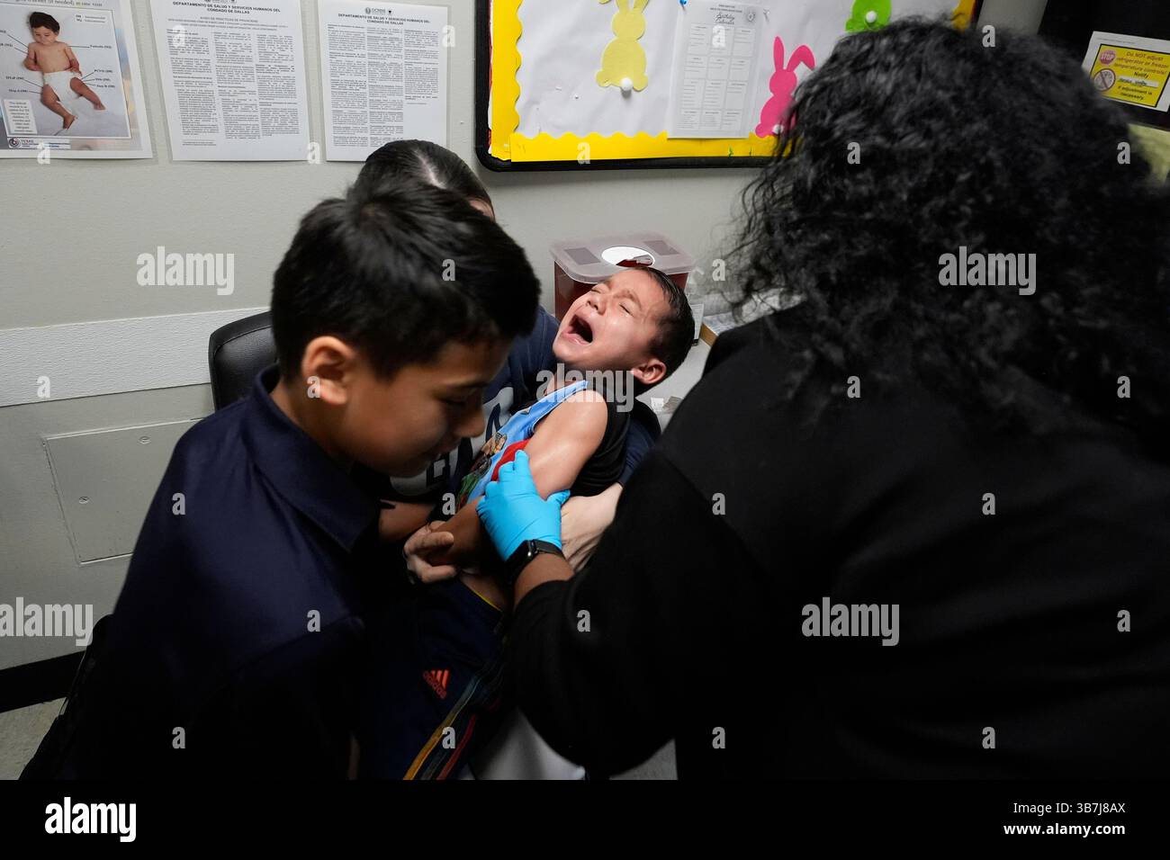 Five-year-old Ian Rojas, center, his held down by by his brother Julian ...