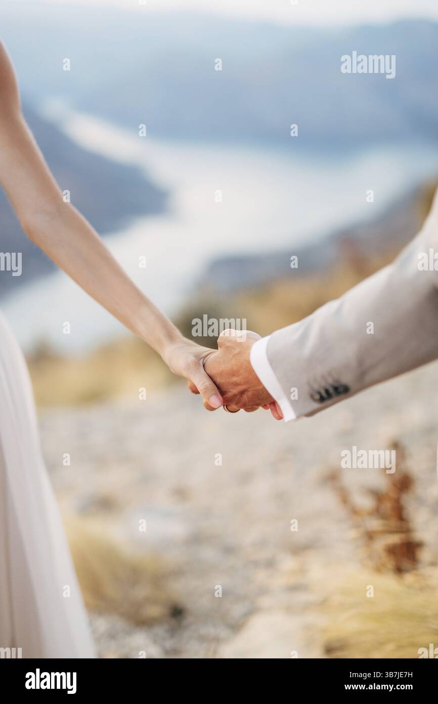 The bride and groom stand on Mount Lovcen overlooking the Bay of Kotor ...