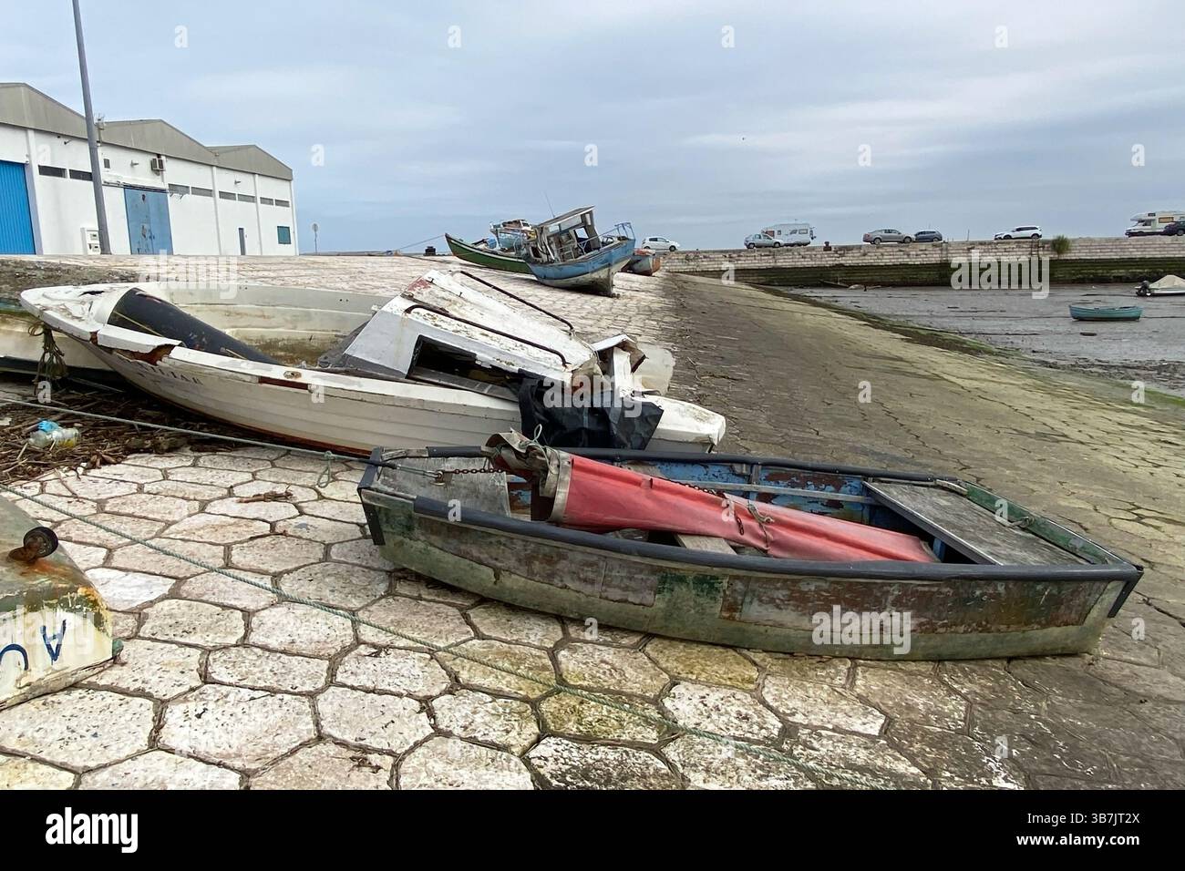 Old fishing trawler with broken parts tied to sea port Stock Photo - Alamy