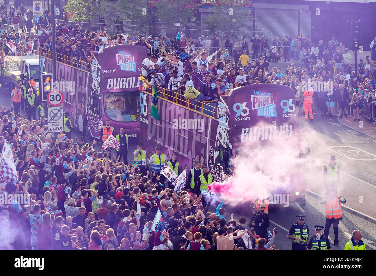 Fans line the street as the Burnley parade buses pass through the town ...