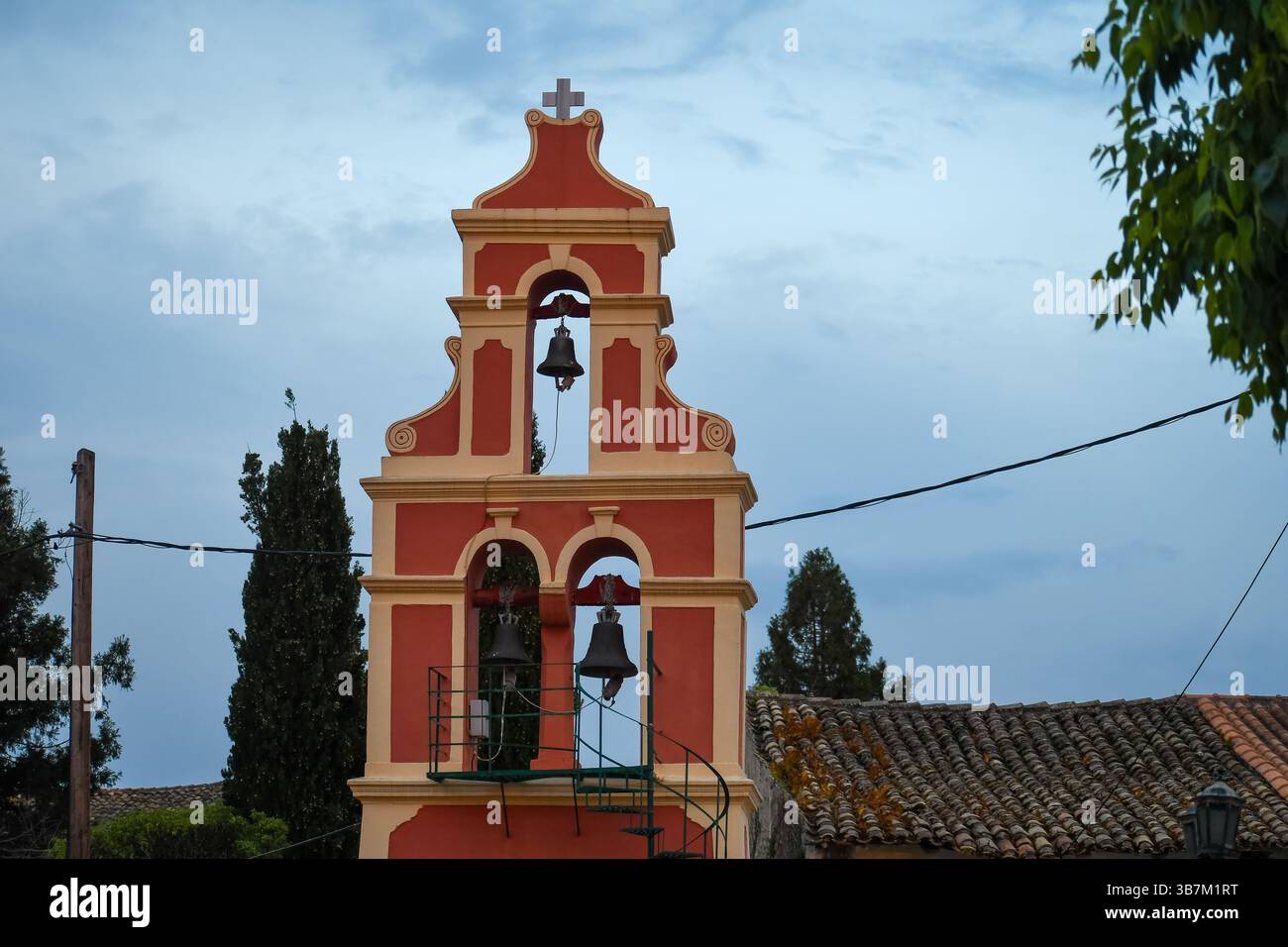 View of a red and tan bell tower featuring multiple bells hanging ...