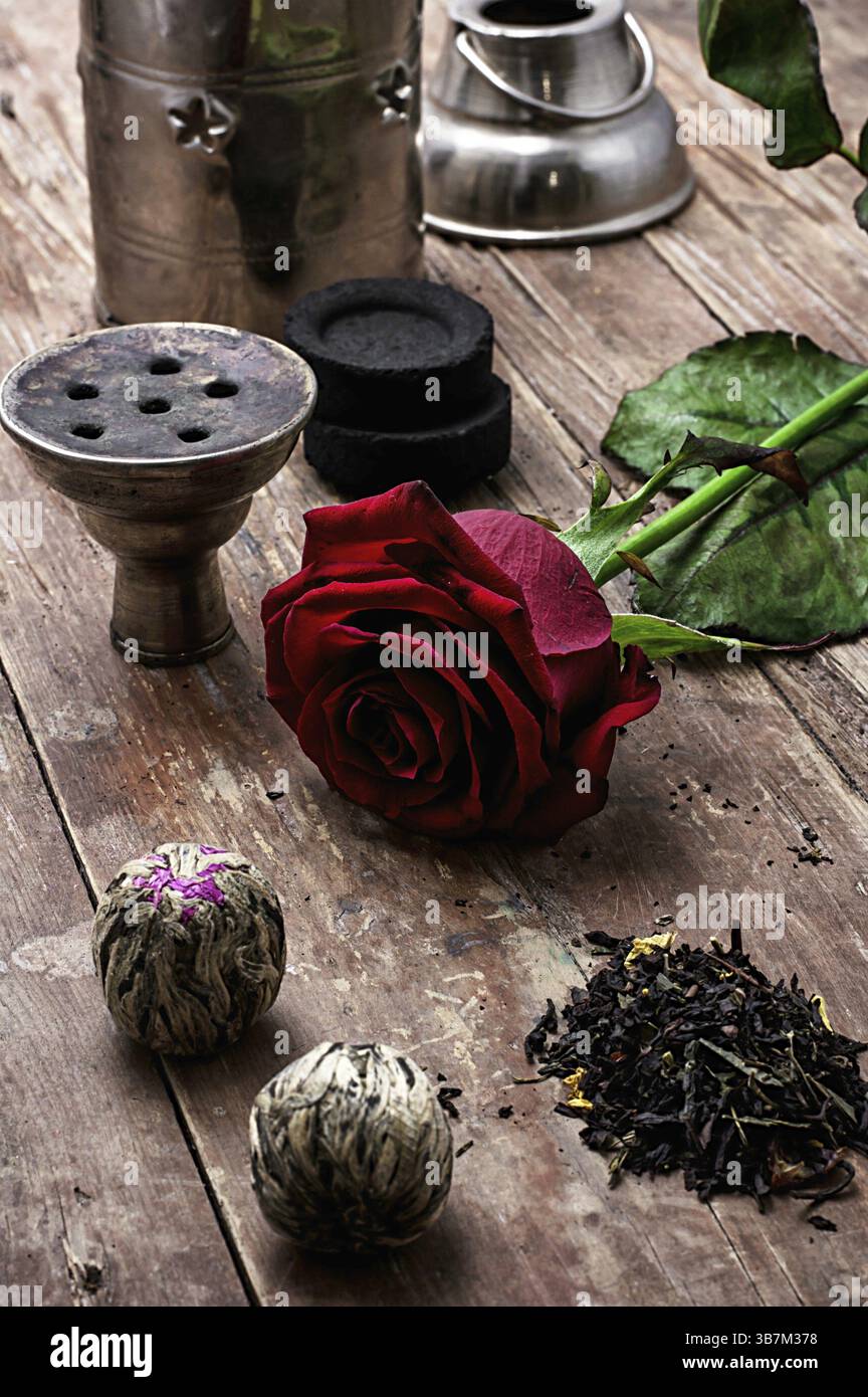 Details hookah and dry elite tea leaves on wooden background.the toned ...