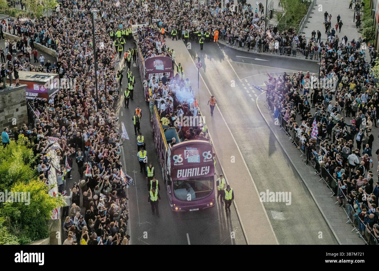 Fans line the street as the Burnley parade buses pass through the town ...