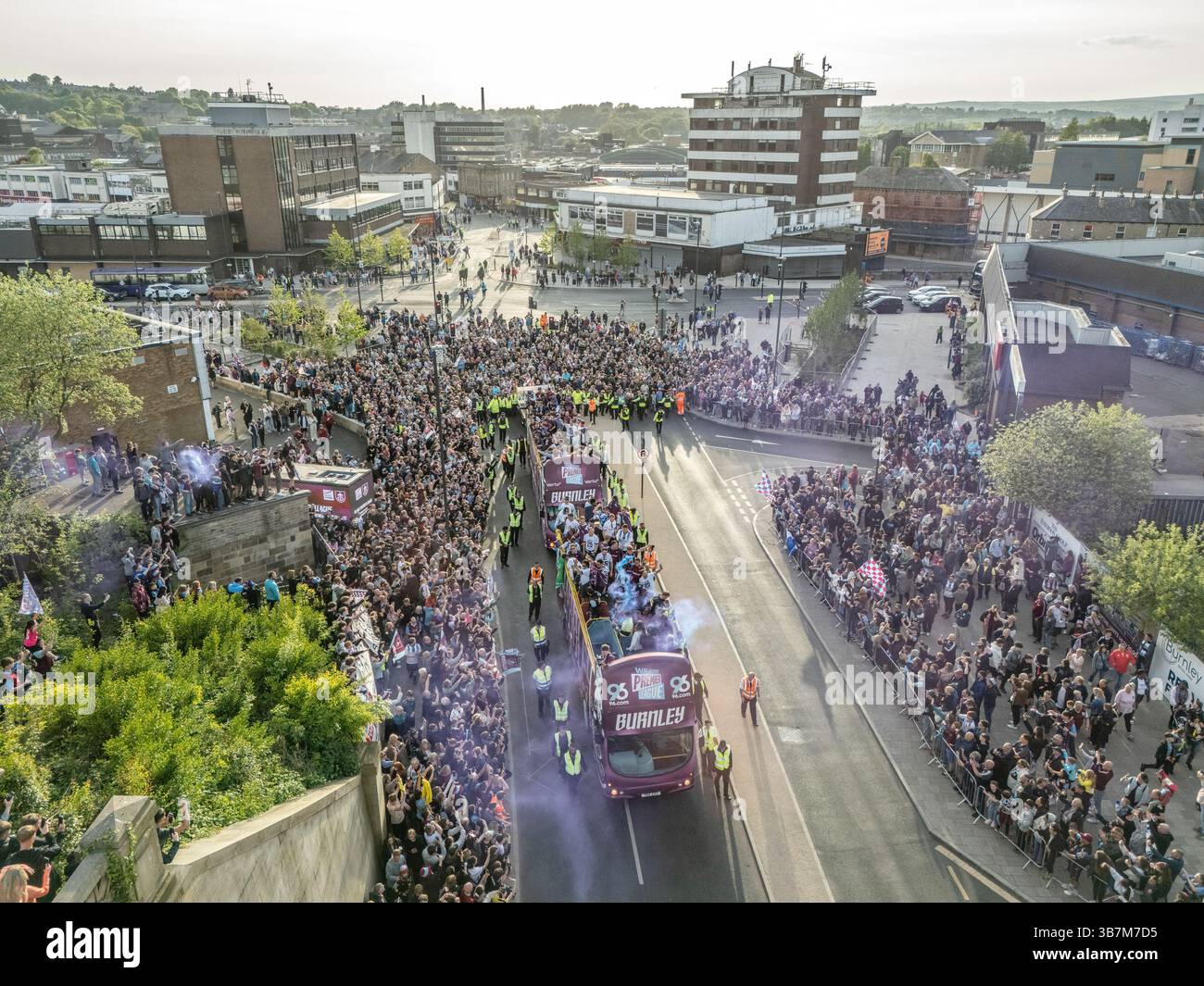 Fans line the street as the Burnley parade buses pass through the town ...