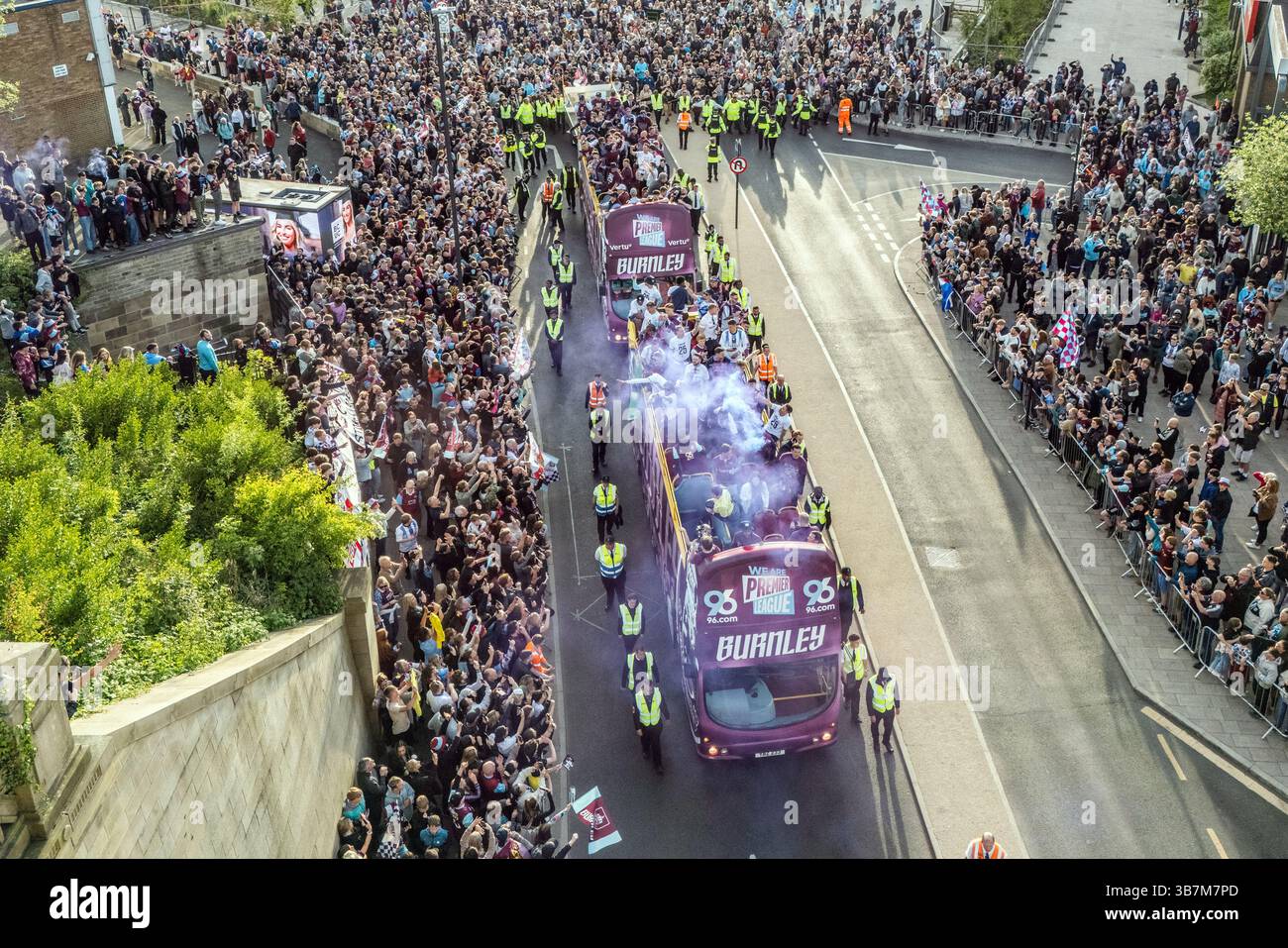 Fans line the street as the Burnley parade buses pass through the town ...