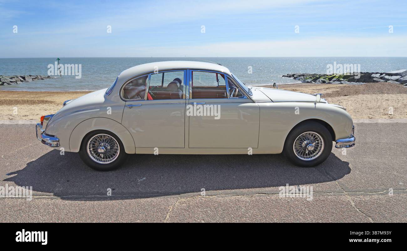 Classic Jaguar MK2 motor car parked on seafront beach and sea in ...