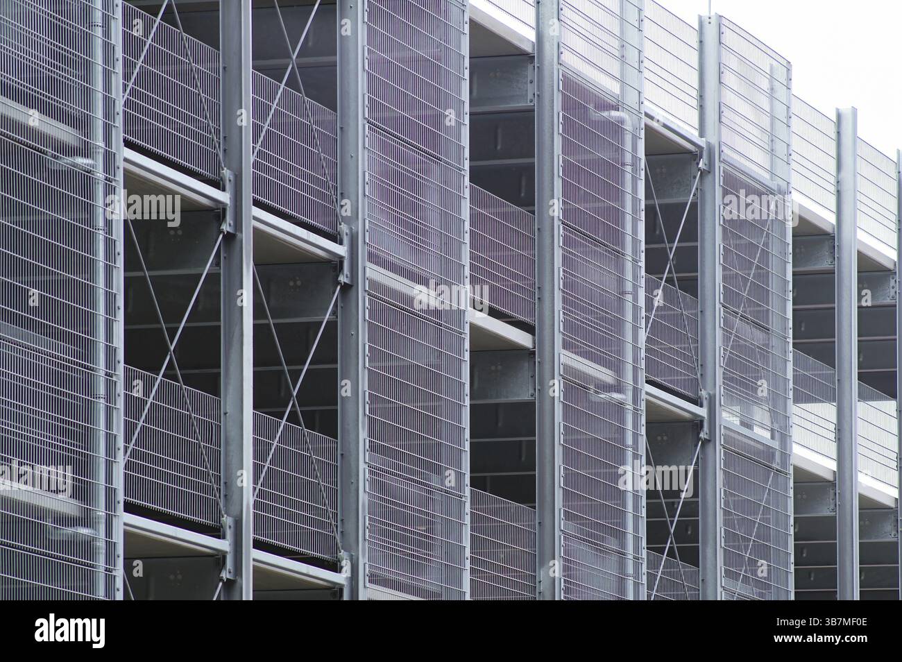 Metal mesh facade creating a visually striking exterior on a modern parking garage, emphasizing ...