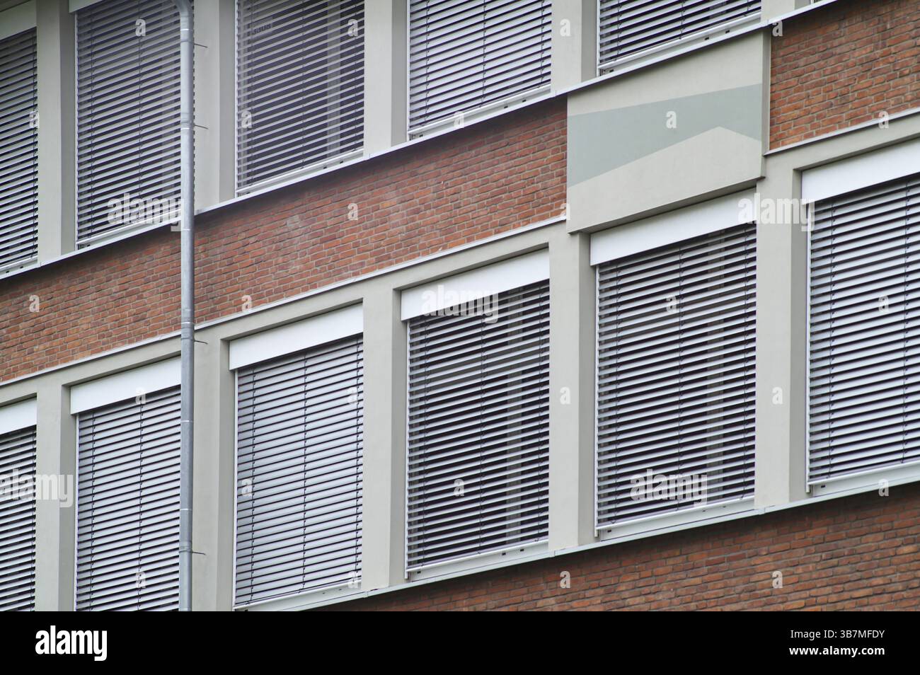 Sunlight filtering through venetian blinds on a contemporary brick ...