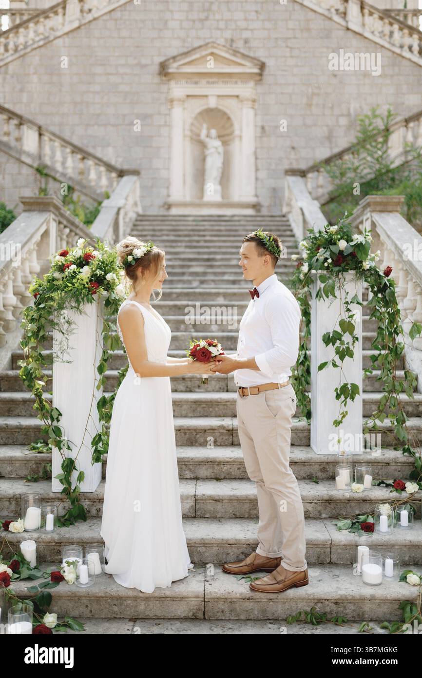 The bride and groom stand on the stairs of the Nativity of the Blessed ...