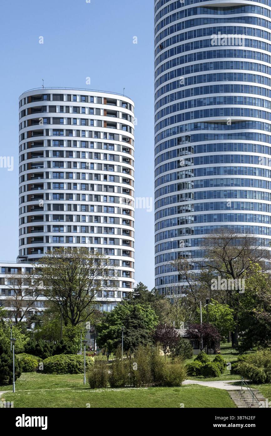 Modern high-rise apartment blocks behind the municipal park under a ...