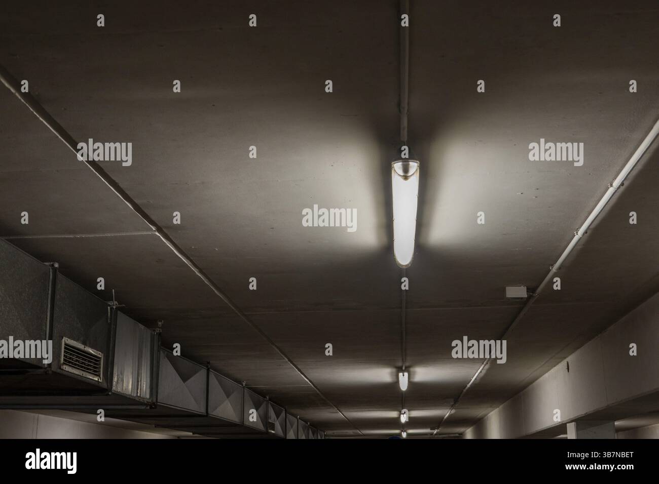 Metal air conditioning and ventilation ducts running along ceiling with ...