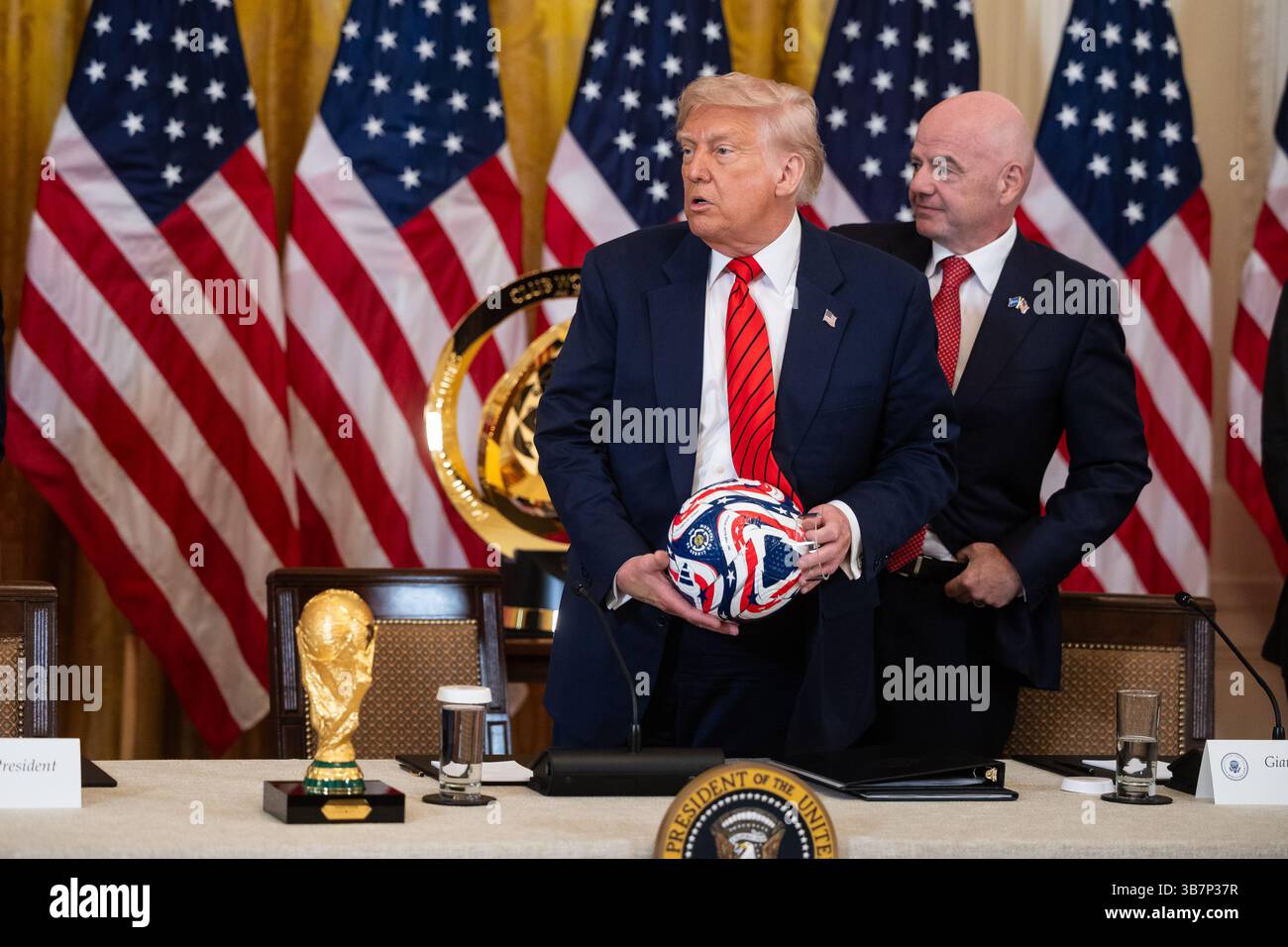 President Donald Trump holds a soccer ball as he and FIFA President Gianni Infantino prepare to ...