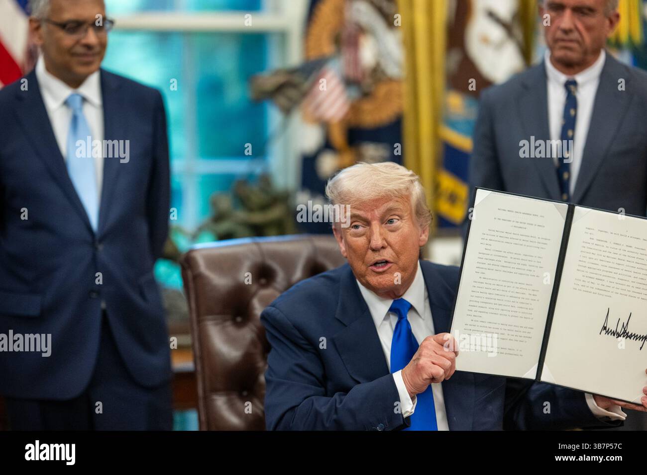 President Donald Trump signs executive orders flanked by Secretary of ...
