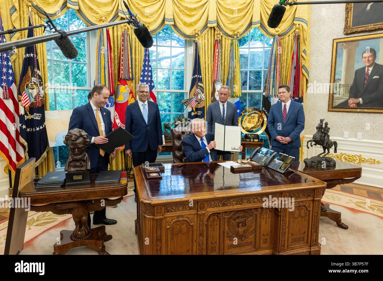 President Donald Trump signs executive orders flanked by Secretary of ...