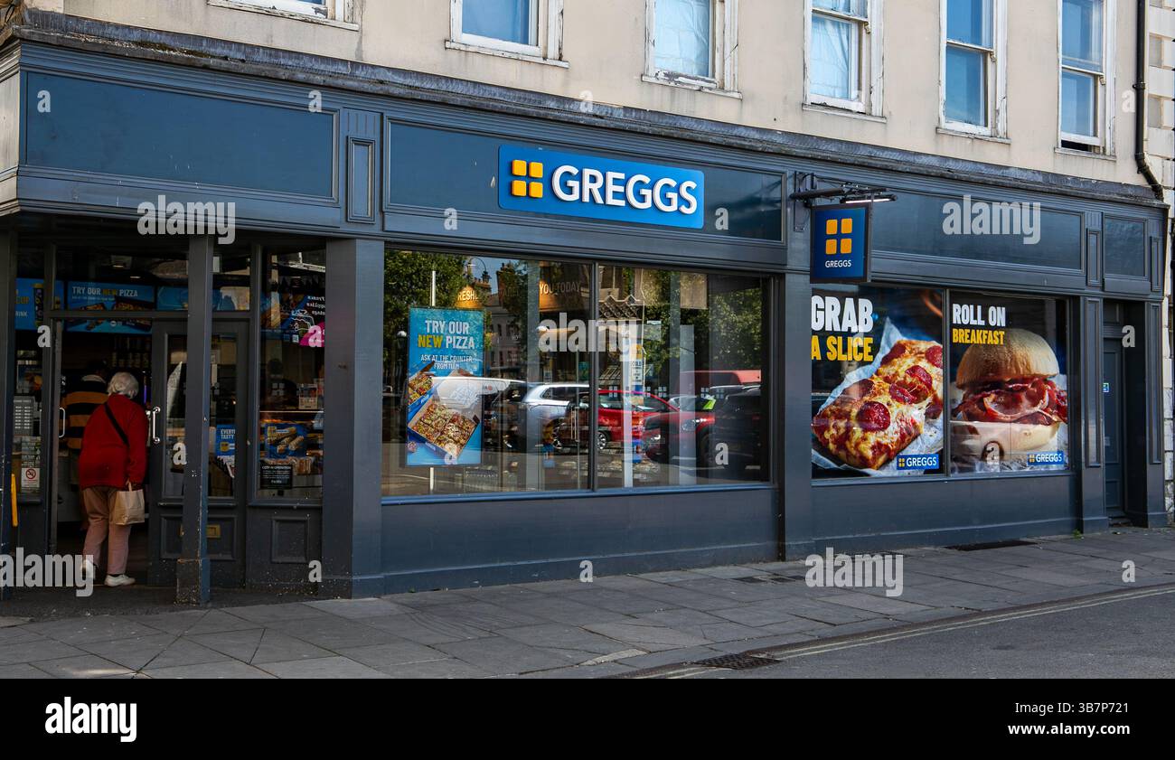 Street view of a Greggs bakery storefront with promotional signage and ...