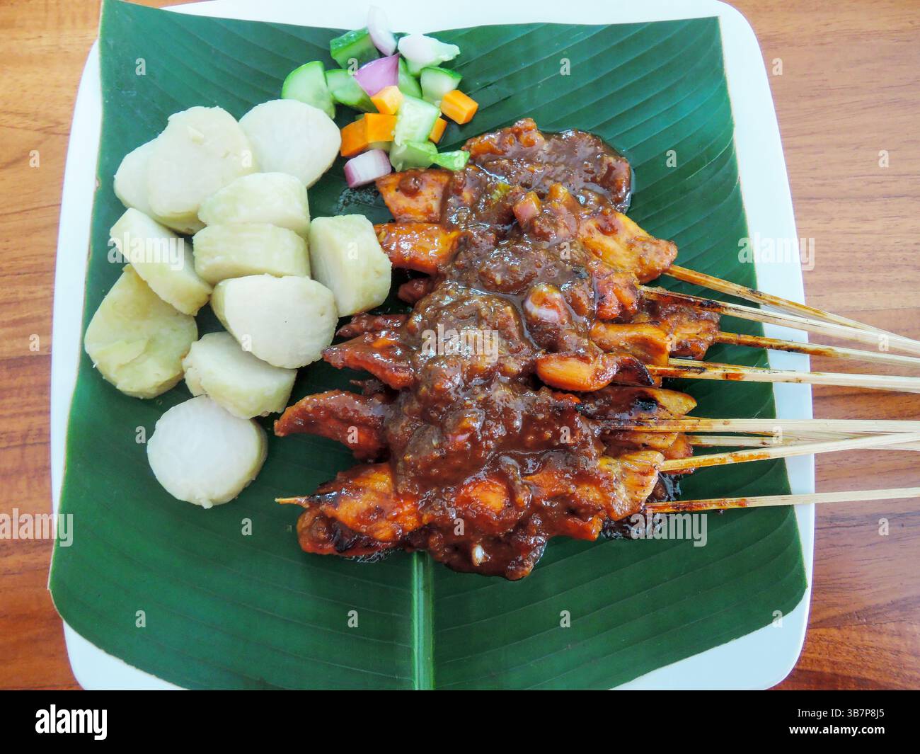 Indonesian Sate Ayam or Chicken Satay with lontong rice cake served on ...