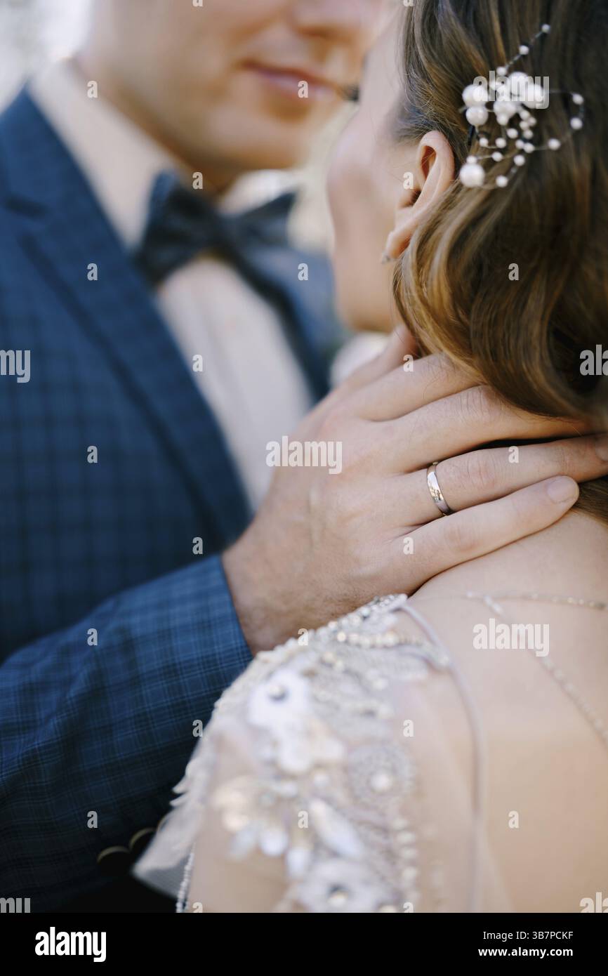 Groom touches bride neck with his hand. Back view. Close-up Stock Photo ...