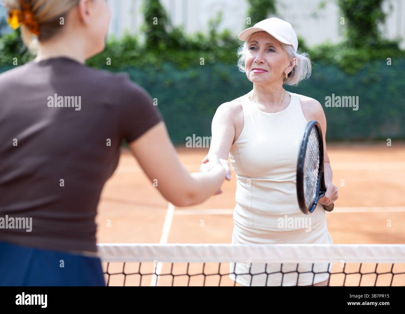 Female tennis players shake hands across net Stock Photo - Alamy
