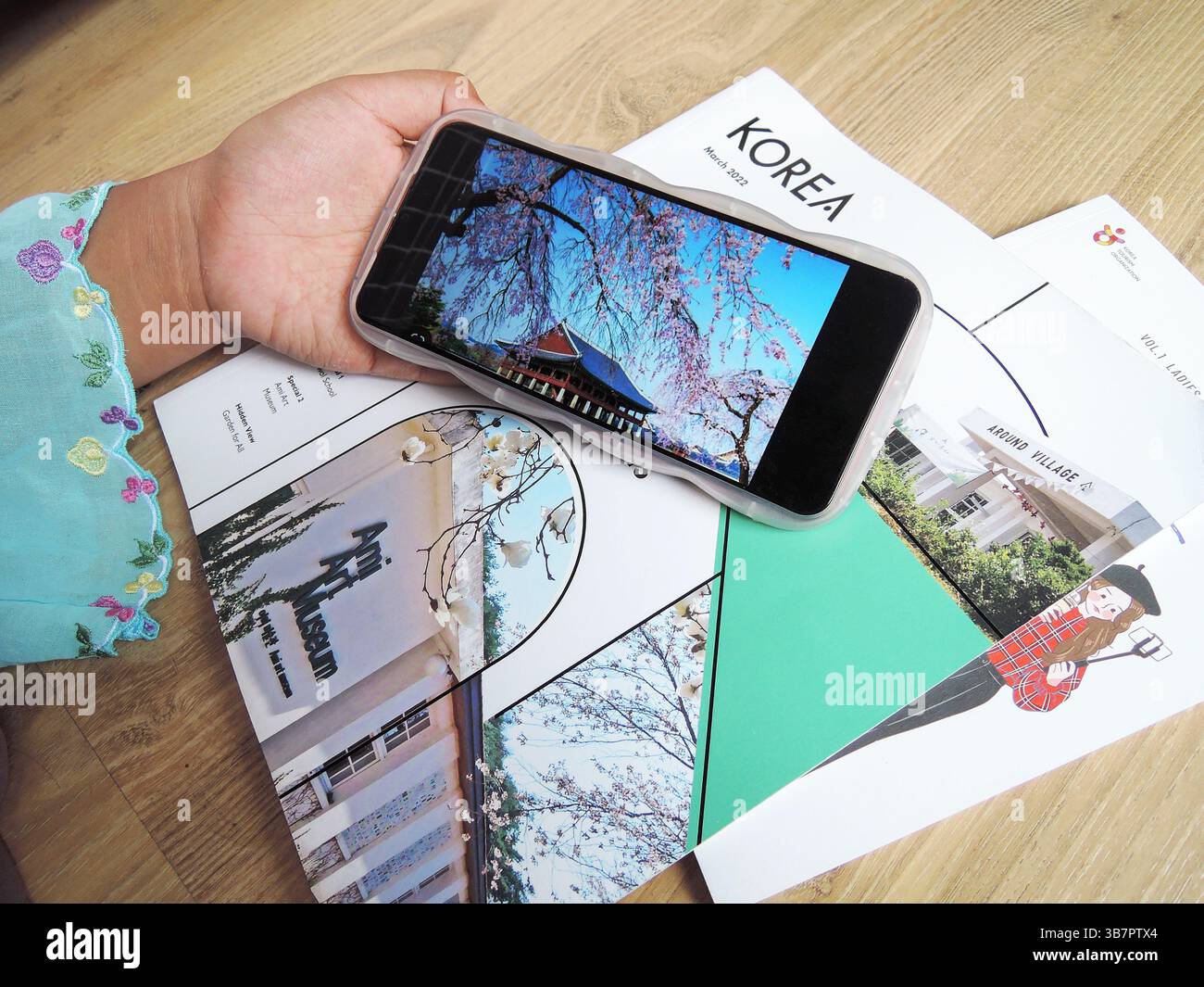 Tourism and travel brochures about South Korea and a mobile phone with ...