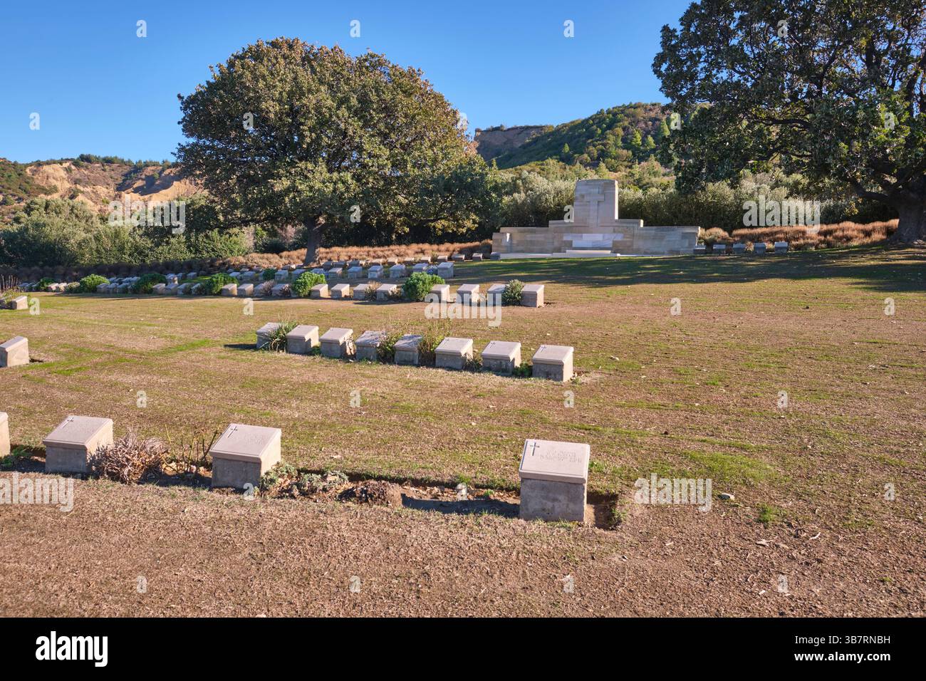 A view of small graves and the main memorial, with cross. At the ...